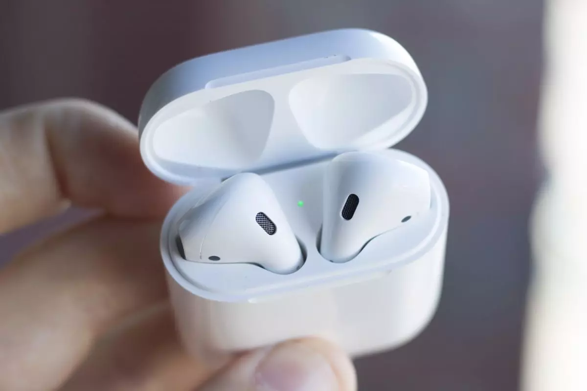 L-ewwel xerrejja ta 'airpods headphones mingħajr fili ġabuhom fl-idejn tagħhom stess.